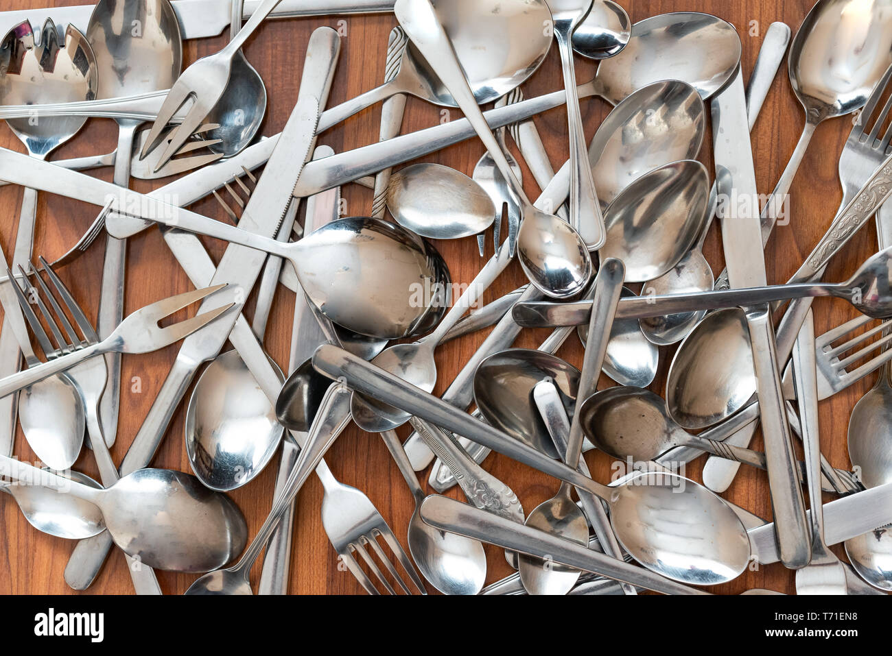 cutlery - knives, spoons and forks lie in disarray Stock Photo - Alamy