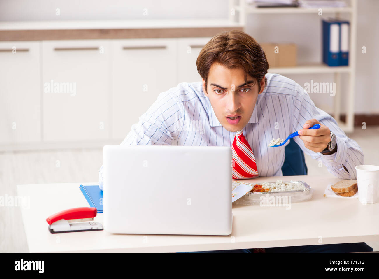 Man having meal at work during break Stock Photo - Alamy