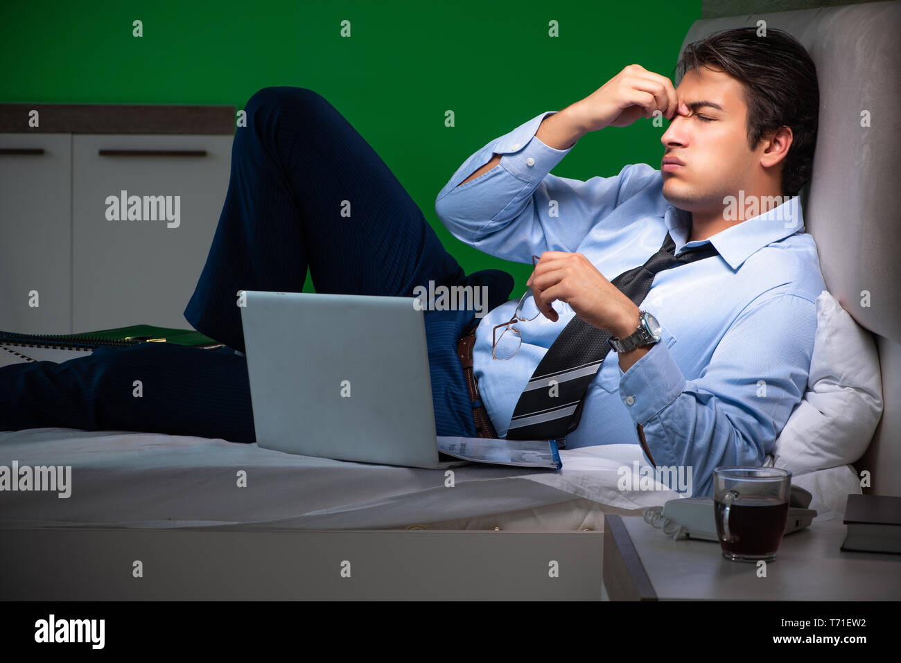 Young businessman under stress in the bedroom at night Stock Photo - Alamy
