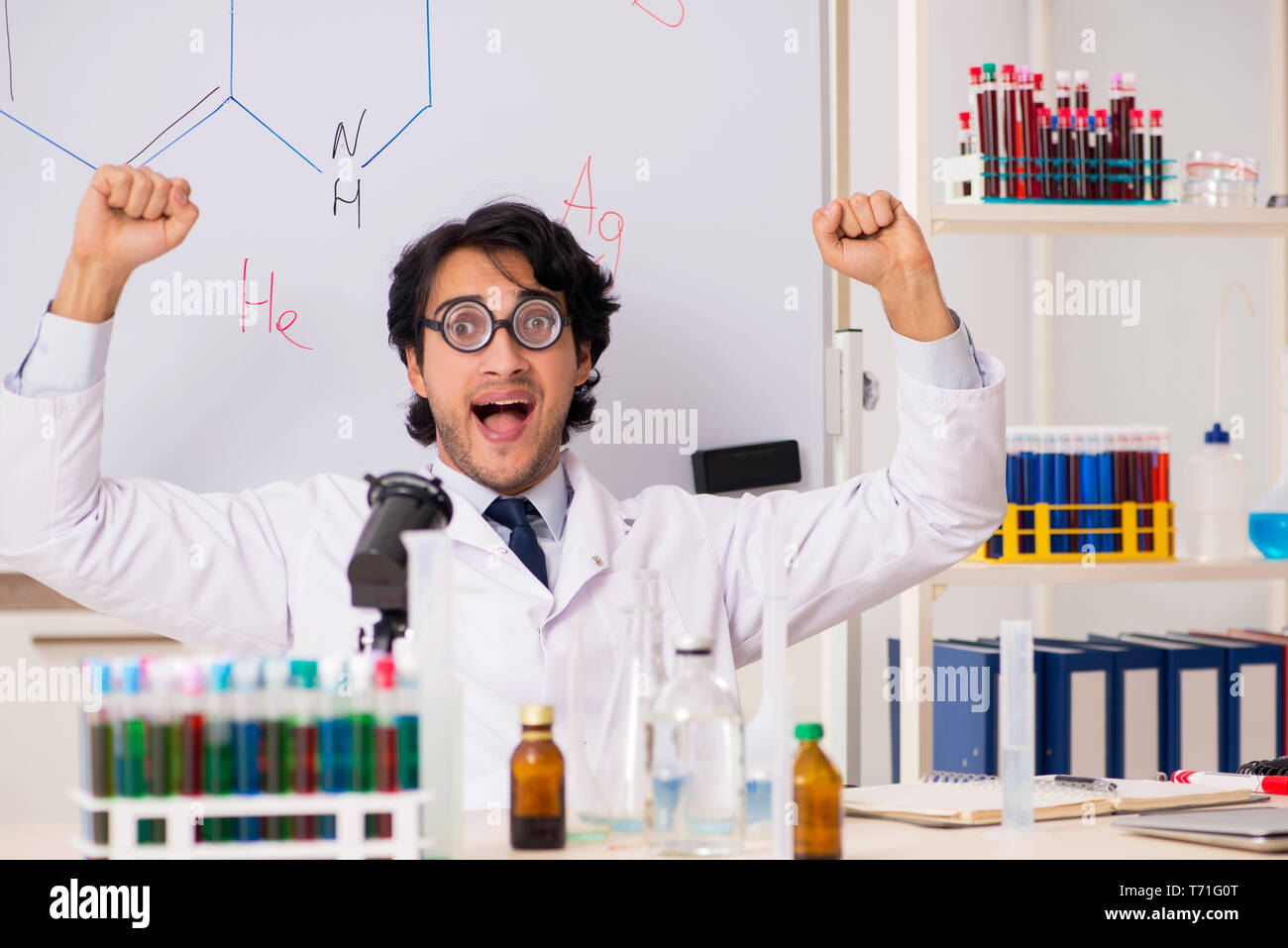 Young funny chemist in front of white board Stock Photo - Alamy