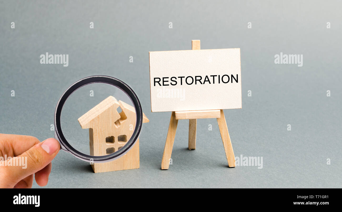 A poster with the inscription Restoration and a broken wooden house ...