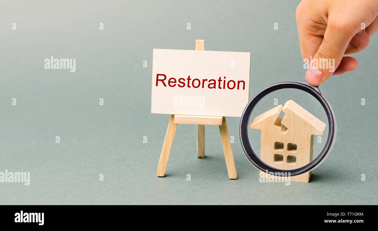 A poster with the inscription Restoration and a broken wooden house ...