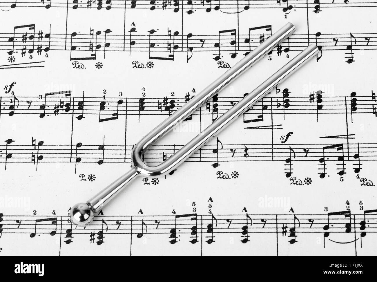 Pitchfork on sheet music - art background Stock Photo - Alamy