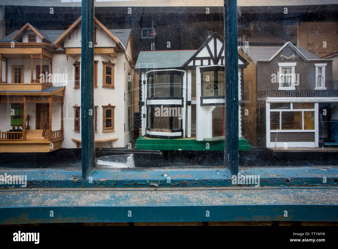 An old shop window weathered and dirty with dust showing a variety of ...