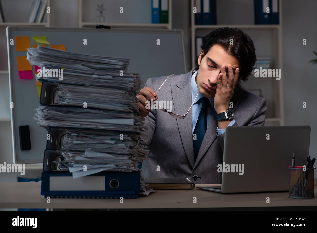 Young male employee working late at office Stock Photo - Alamy