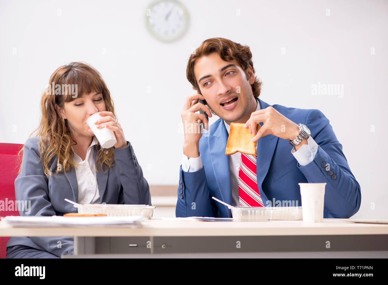 Two colleagues having lunch break at workplace Stock Photo - Alamy