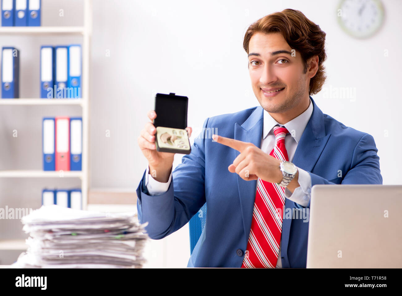 Deaf employee using hearing aid in office Stock Photo - Alamy