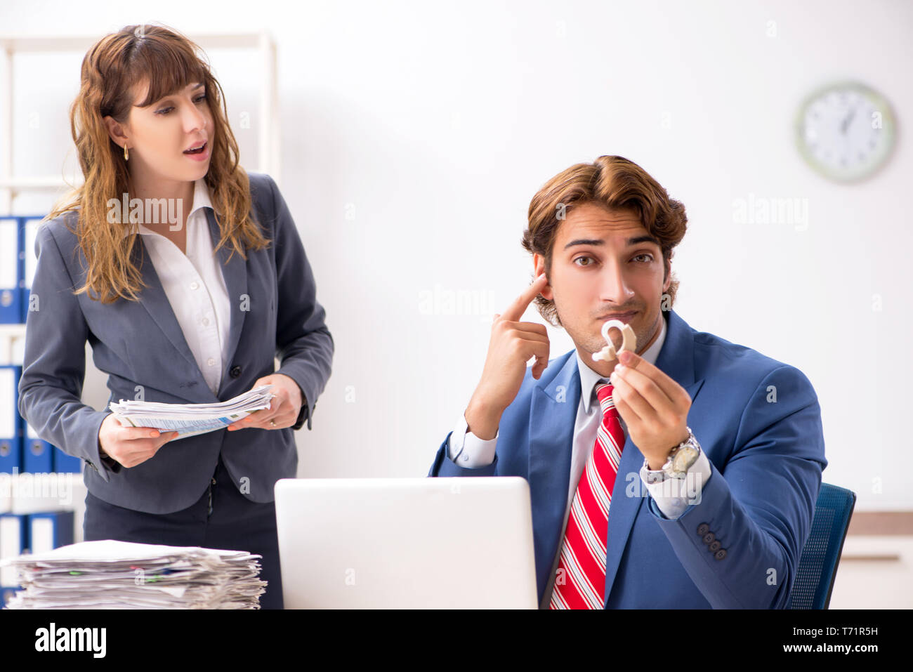 Deaf employee using hearing aid talking to boss Stock Photo - Alamy