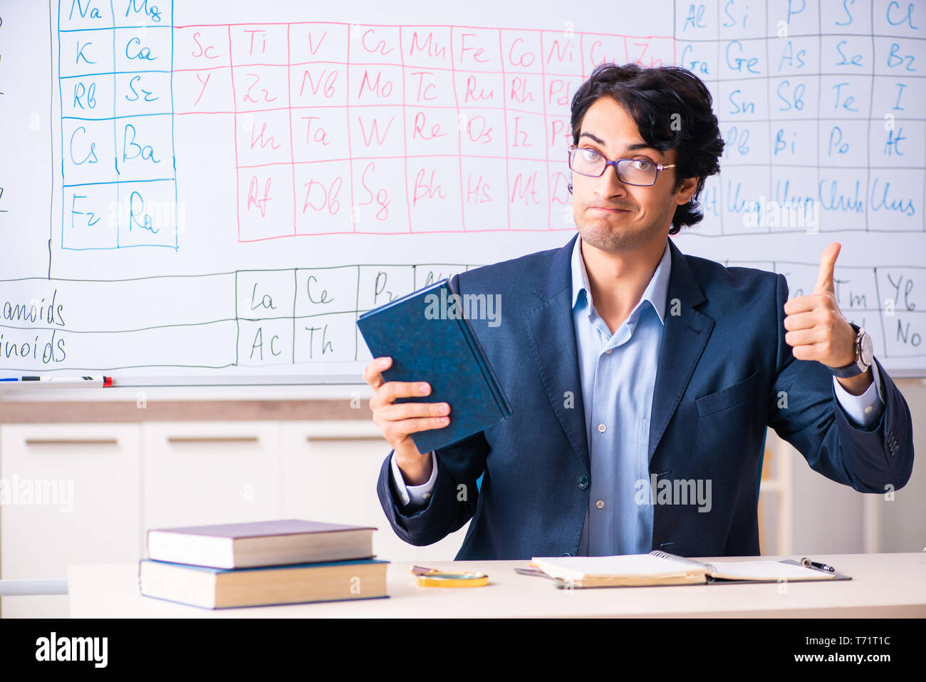 Young male chemistry teacher in front of periodic table Stock Photo - Alamy