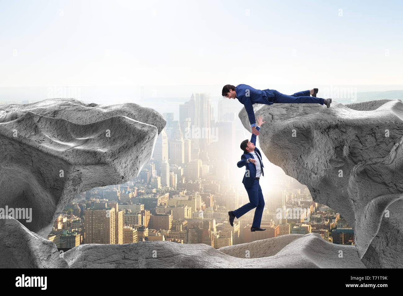 Businessman offering helping hand to falling colleague Stock Photo - Alamy