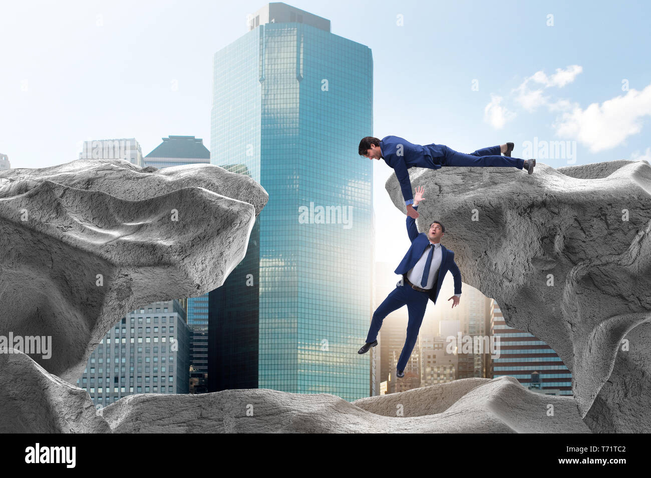 Businessman offering helping hand to falling colleague Stock Photo - Alamy