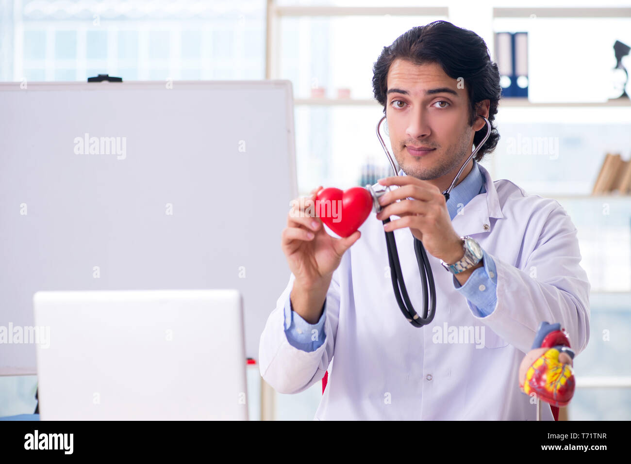 Young handsome doctor cardiologist in front of whiteboard Stock Photo ...