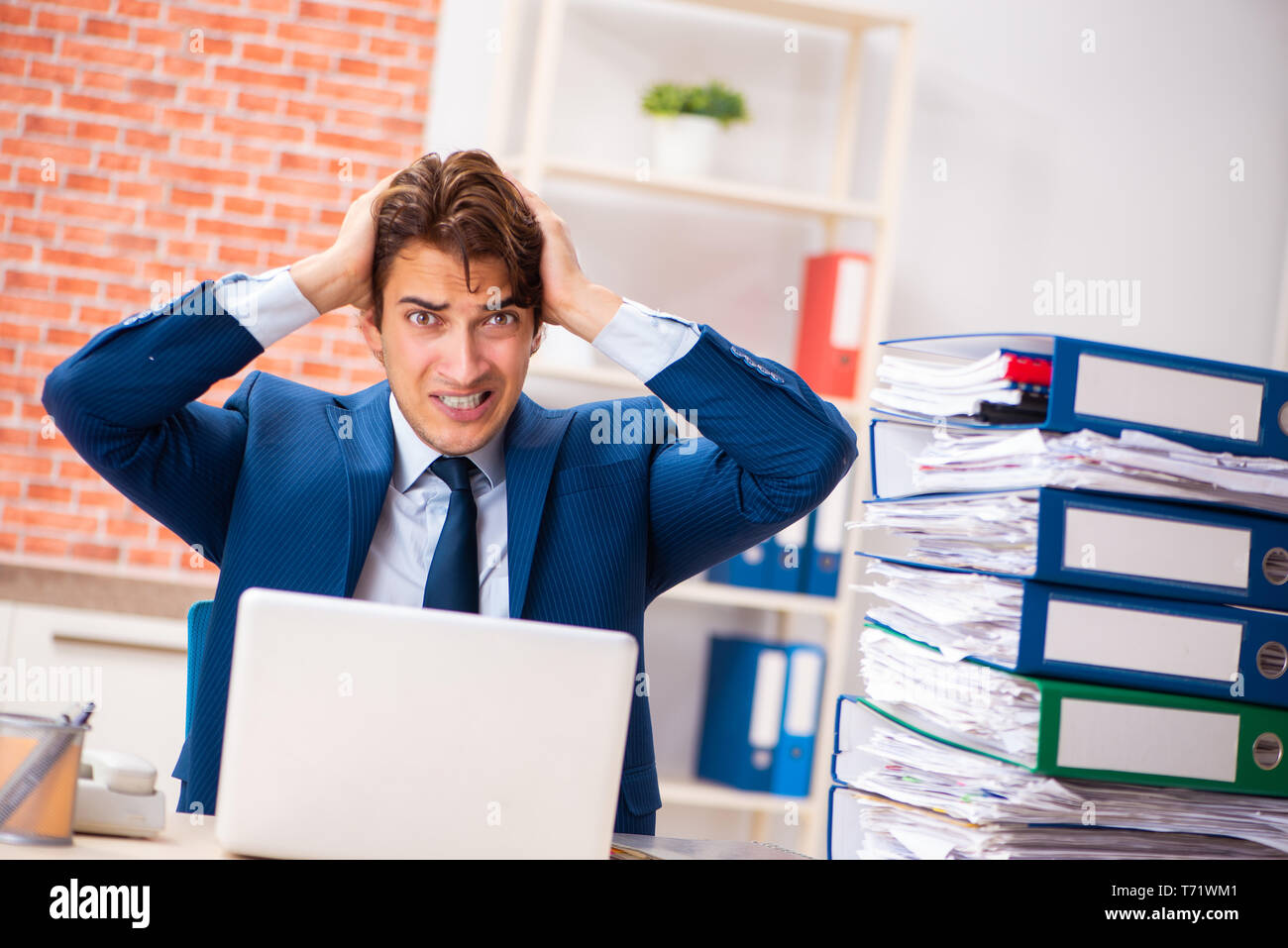 Young elegant man unhappy with too much work Stock Photo - Alamy