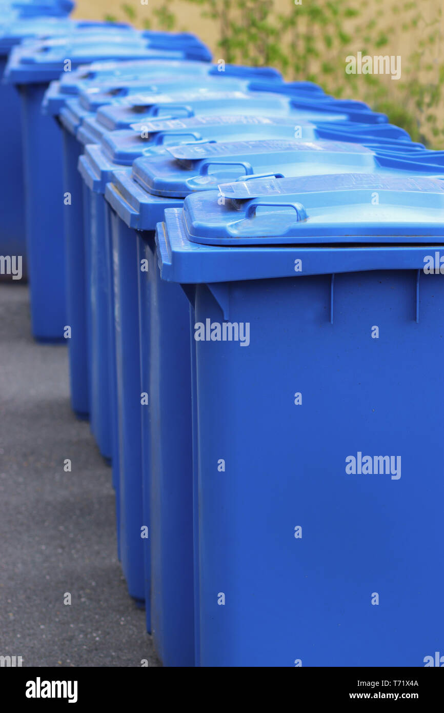 row of blue plastic garbage cans standing at the roadside Stock Photo ...