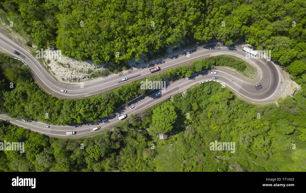 Curvy windy road in green forest, top down aerial view Stock Photo - Alamy