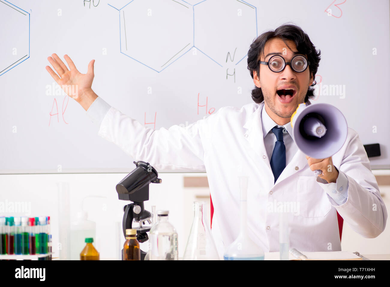 Young funny chemist in front of white board Stock Photo - Alamy