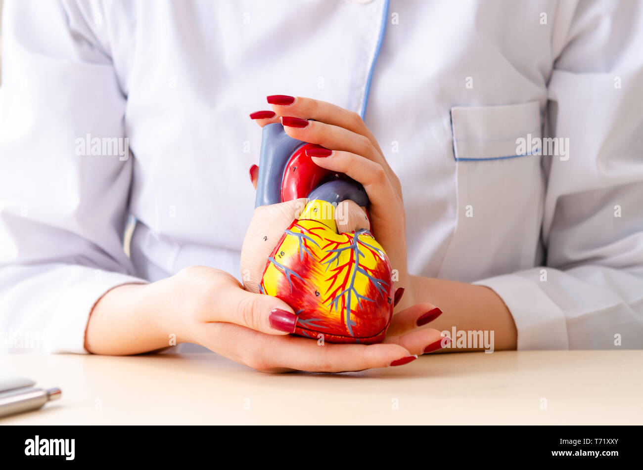 Young female doctor cardiologist sitting at the hospital Stock Photo ...