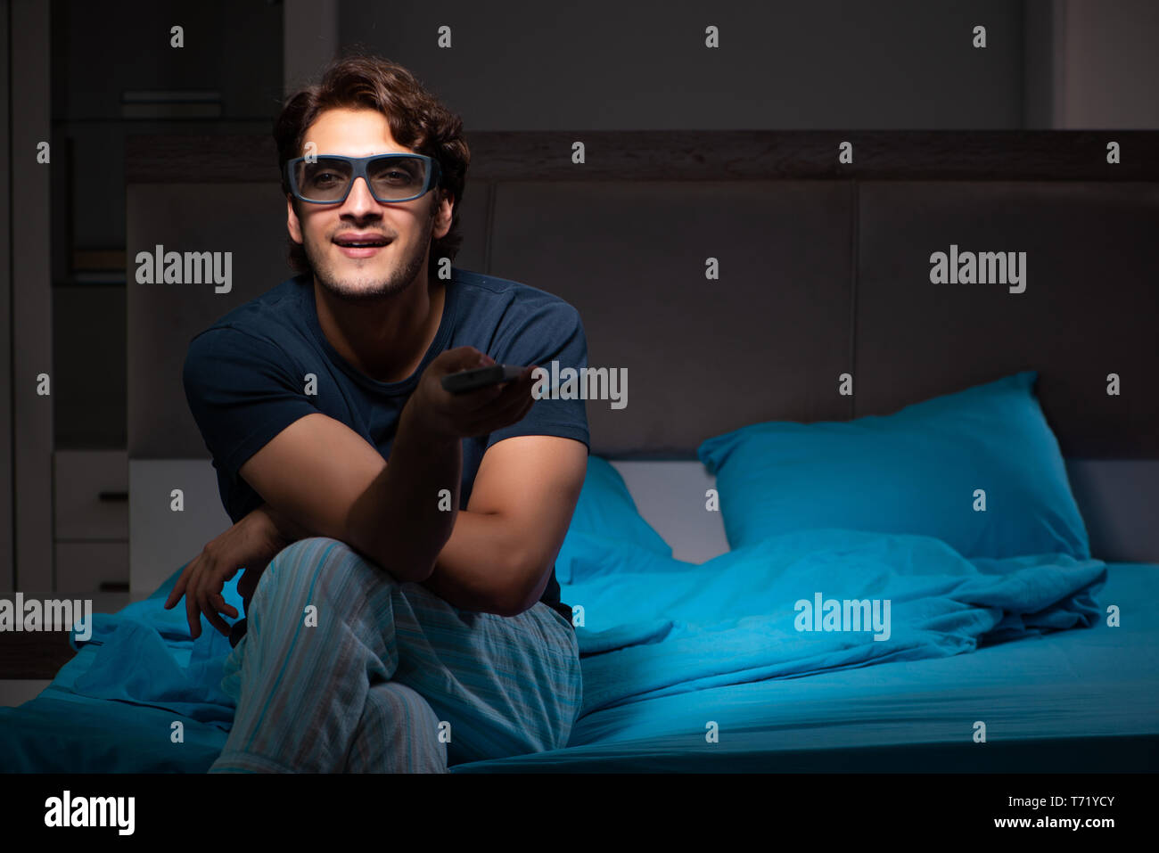 Man watching tv at night in bed Stock Photo - Alamy