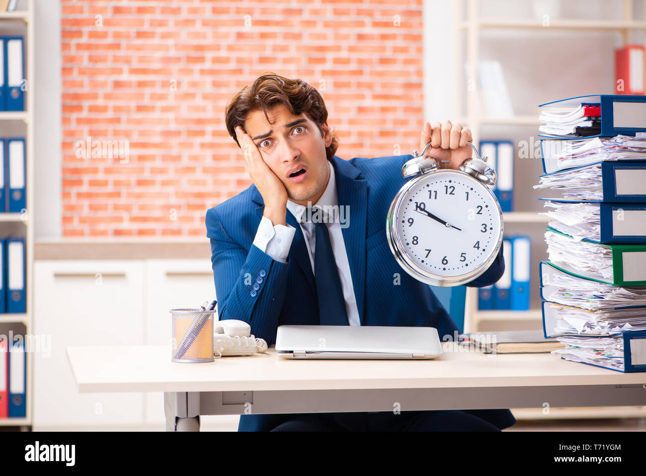 Young elegant man unhappy with too much work Stock Photo - Alamy