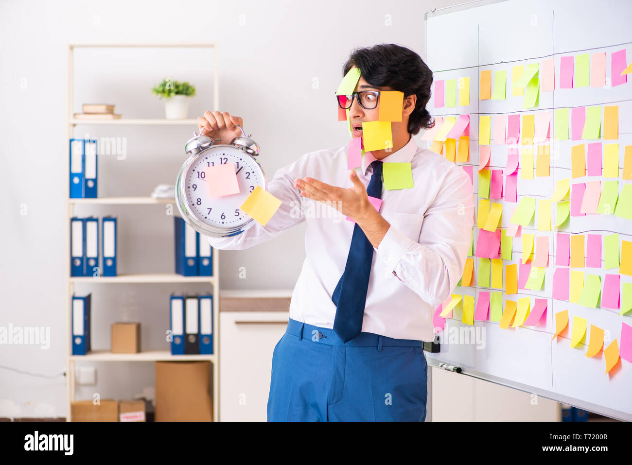 Young employee in conflicting priorities concept Stock Photo - Alamy