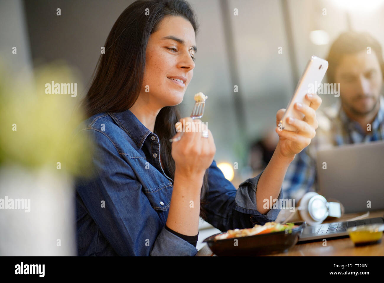 Beautiful woman eating lunch whilst working in co working space Stock ...