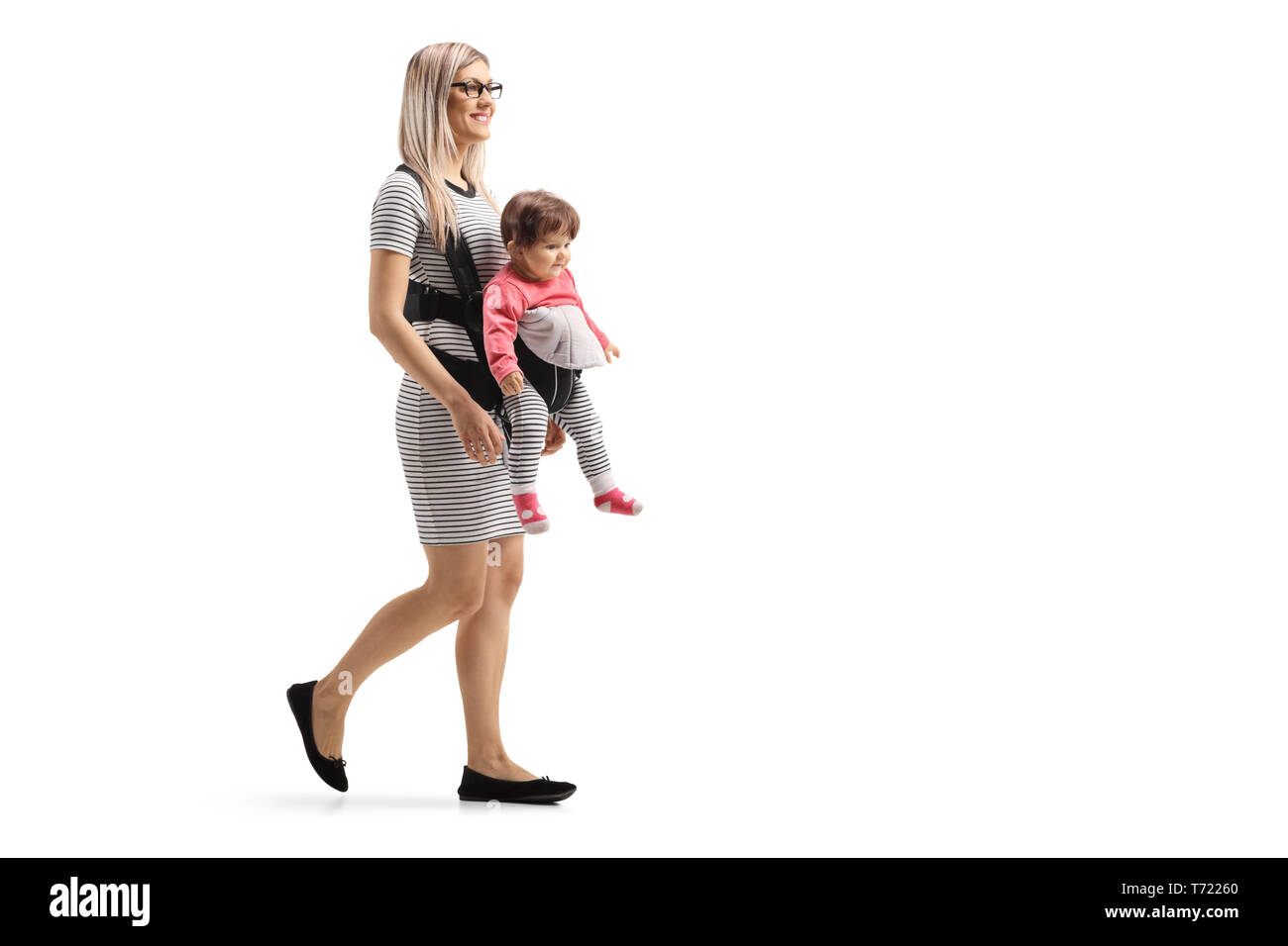 Full length shot of a mother walking with a baby in a carrier isolated ...