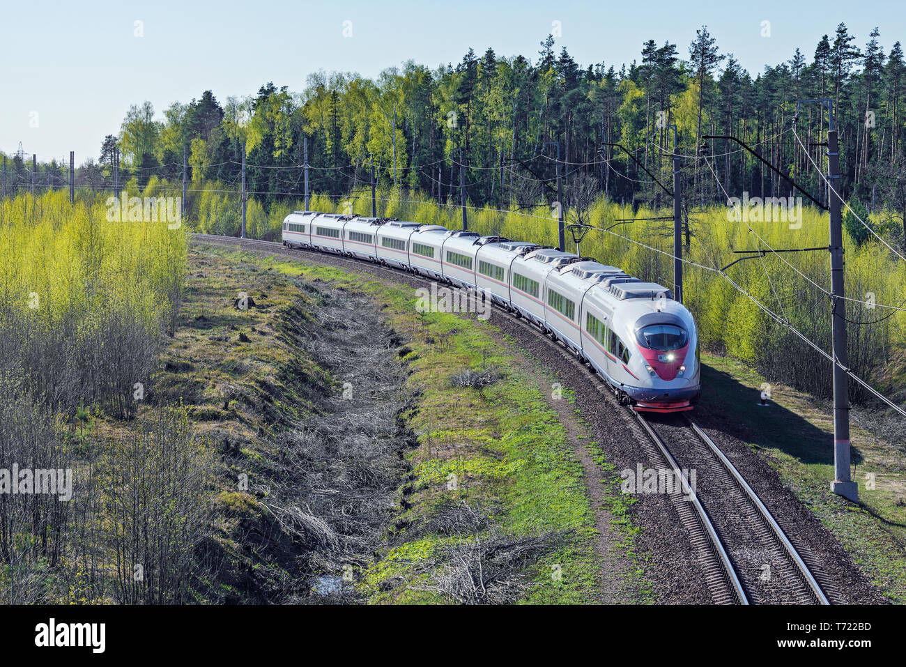 Modern high-speed train approaches to the station at spring morning ...