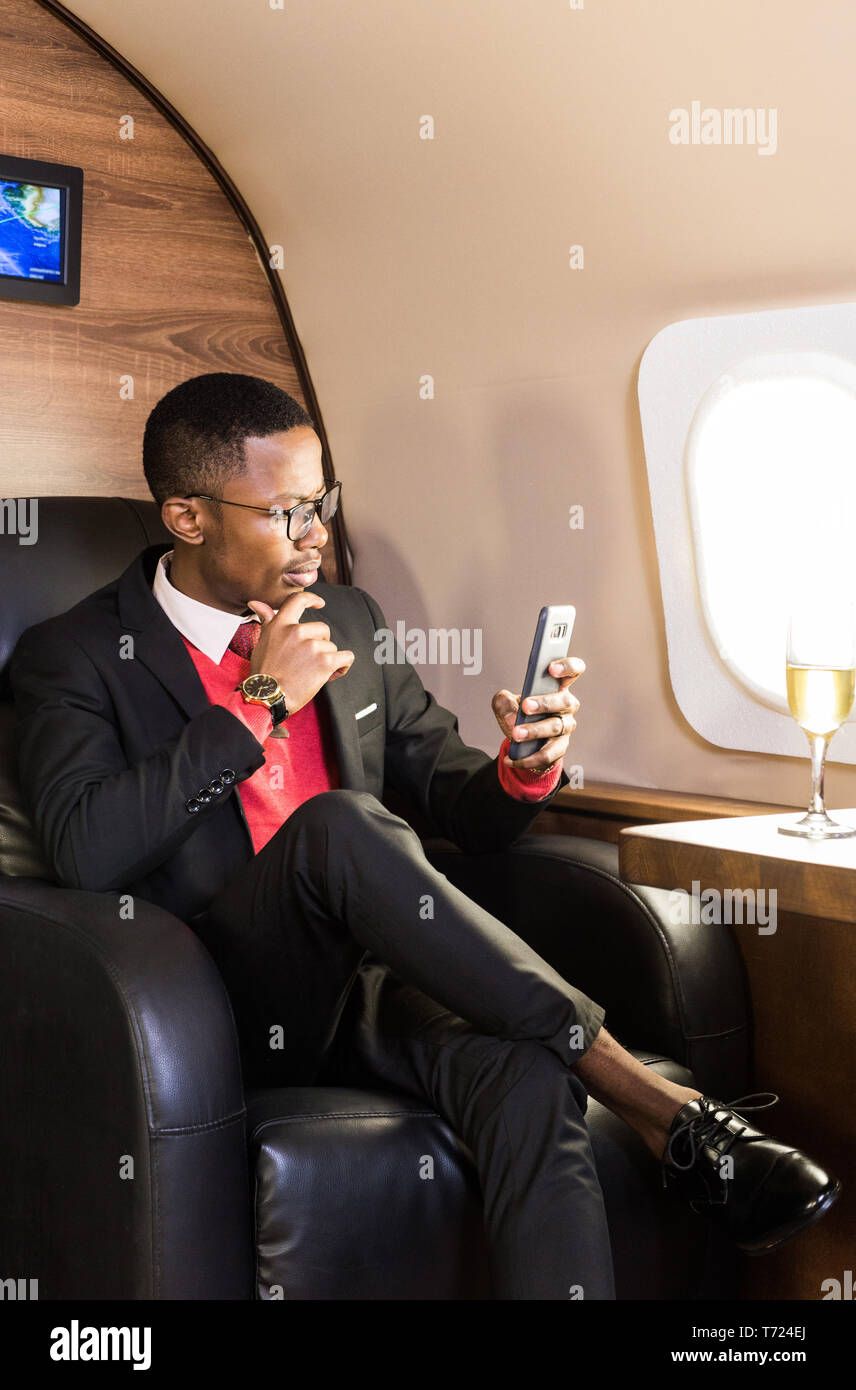 Successful young Afro American black businessman sitting in the chair ...