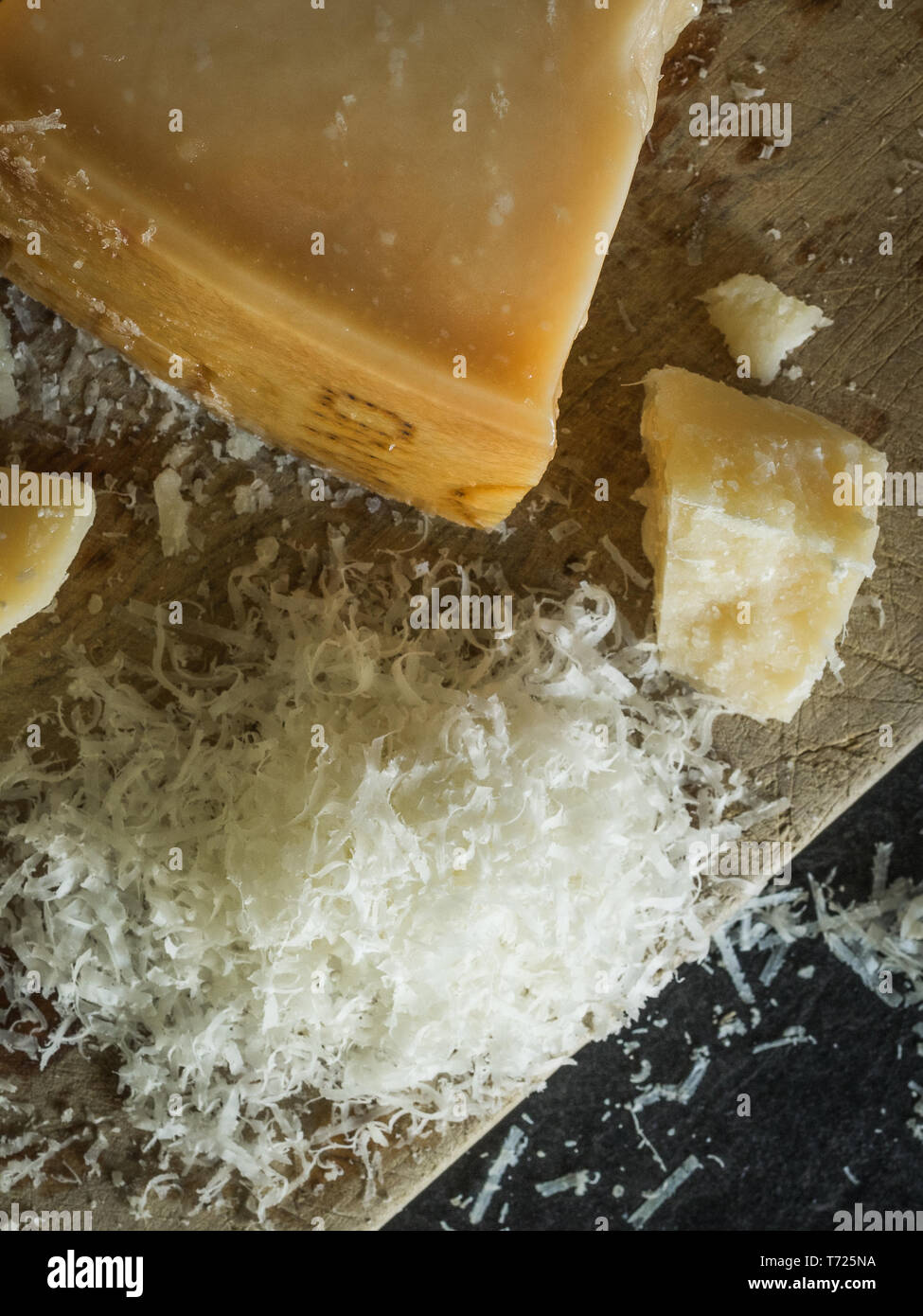 Grated parmesan cheese on black background, italian food. Dark food ...
