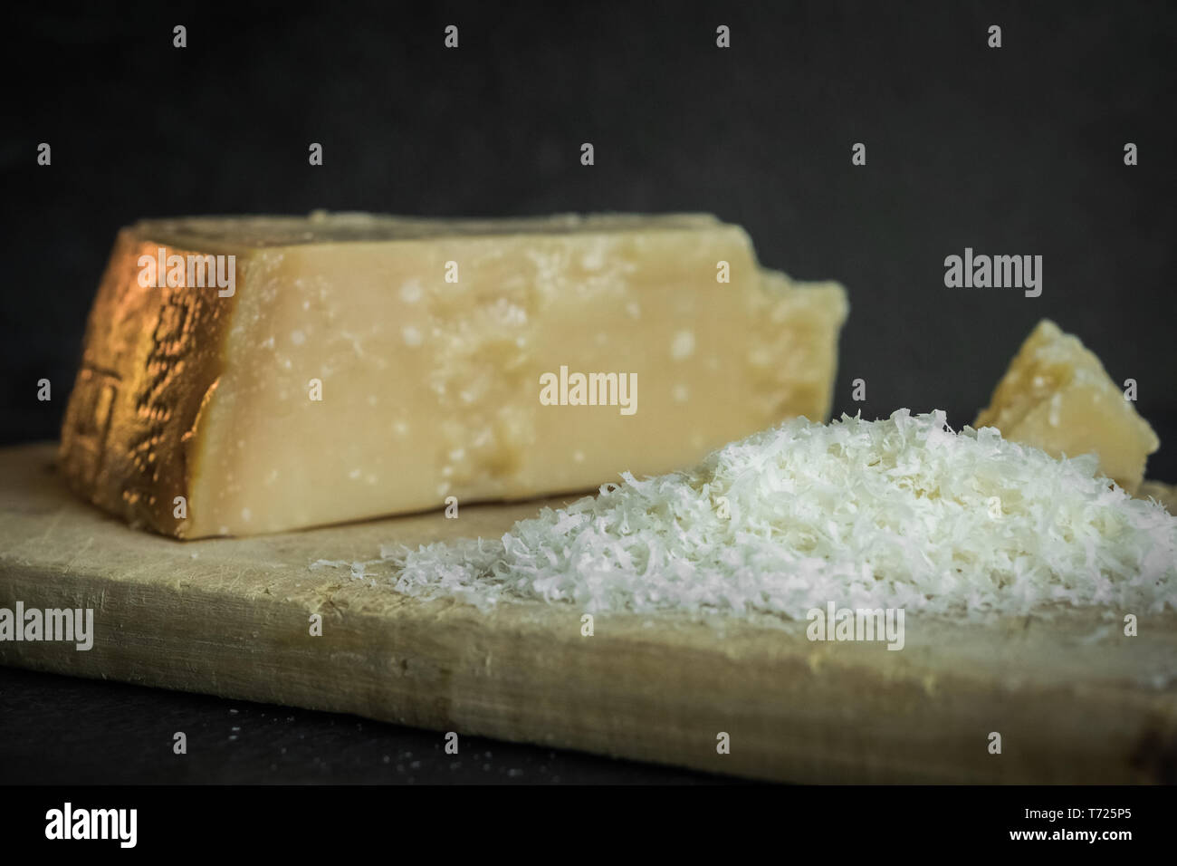 Grated parmesan cheese on black background, italian food. Dark food ...