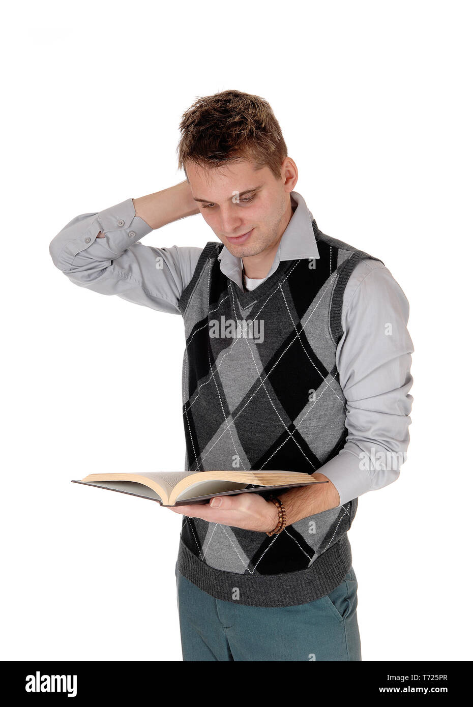 Young man standing reading his book hand on head Stock Photo - Alamy