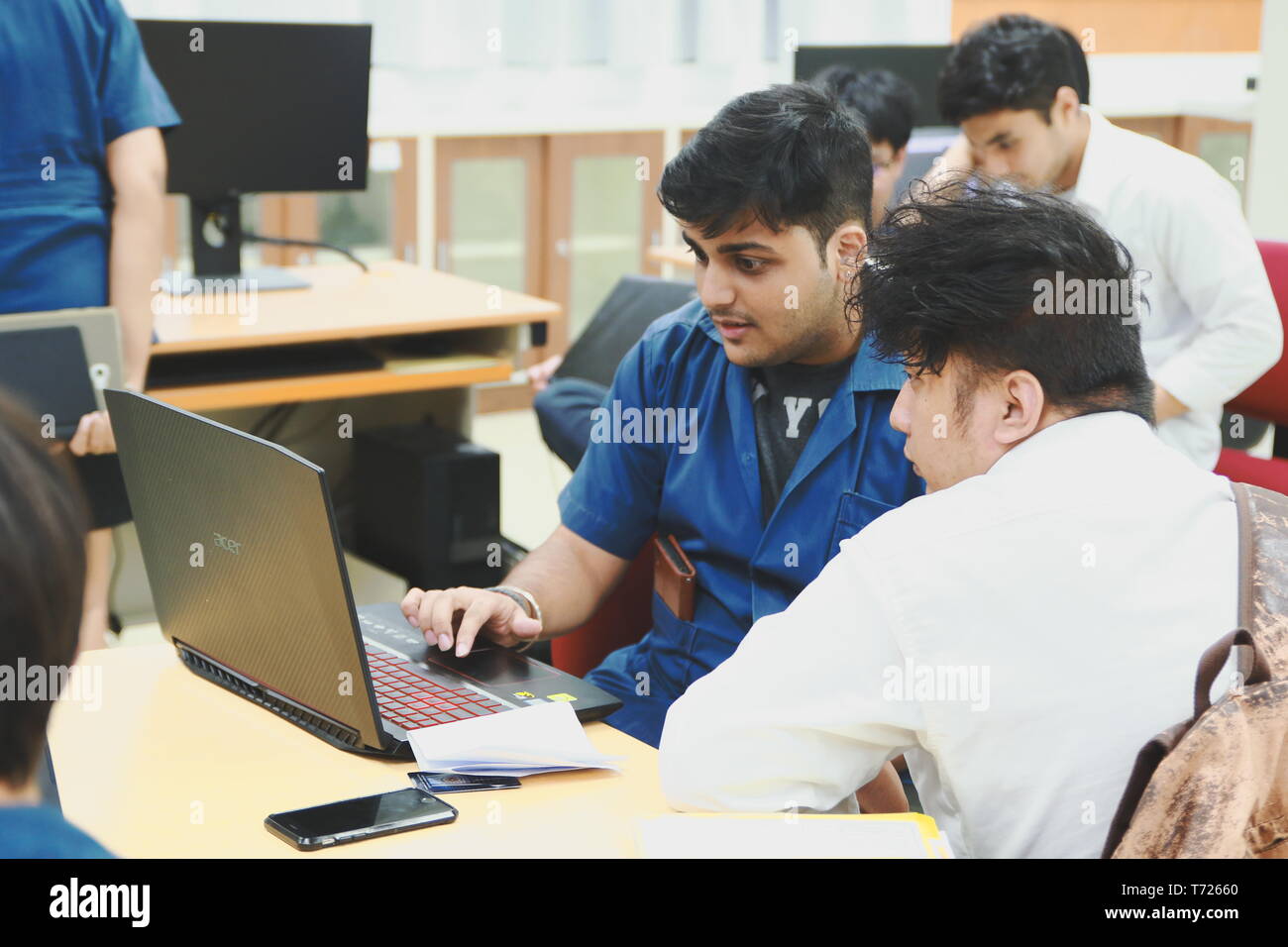 Group of multi ethnic computer engineering students working together to ...