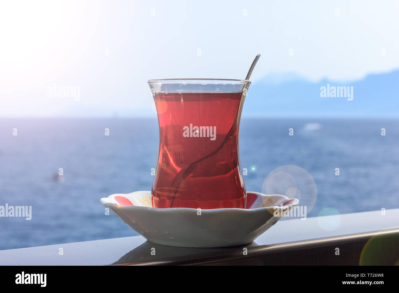 Turkish black tea in traditional glass on background of the blue ...