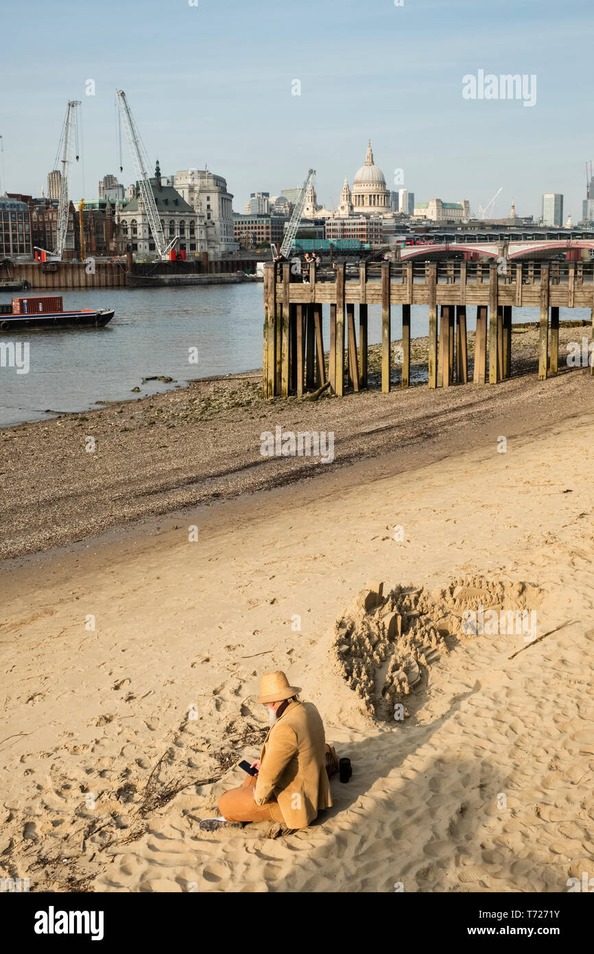 London, UK. A sand sculptor on Ernie's Beach, a public beach on the ...
