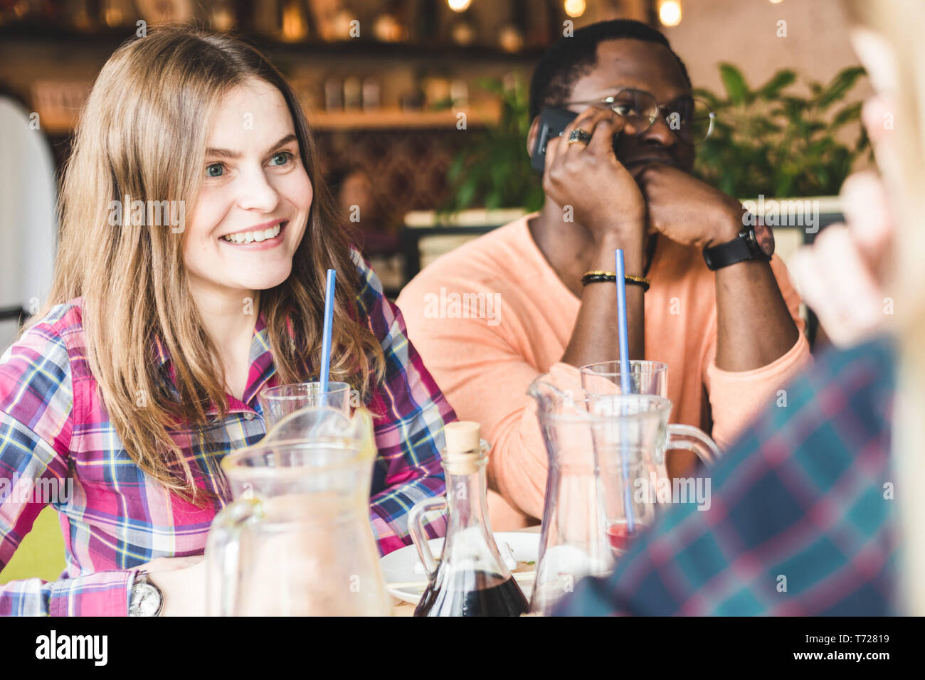 Meet young attractive people in the cafe. Friends chat, have fun, drink ...