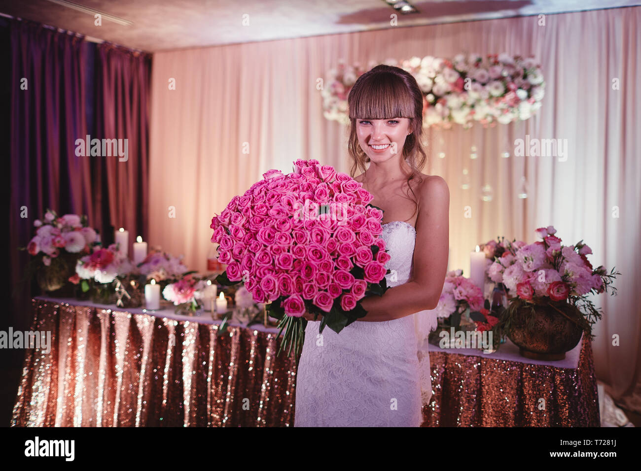 happy bride with a large bouquet of roses. beautiful young smiling ...