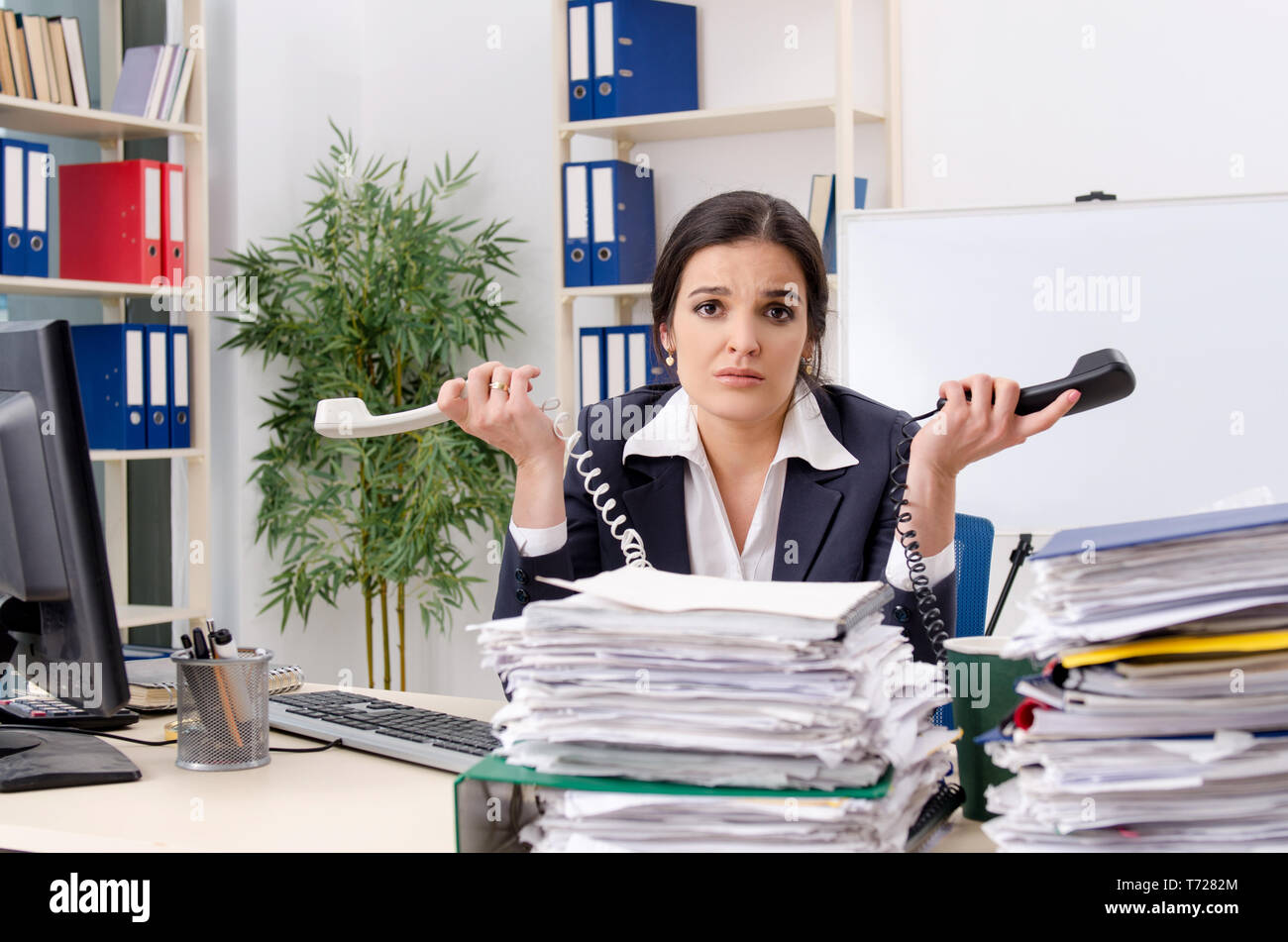 Female employee with too much work in the office Stock Photo - Alamy