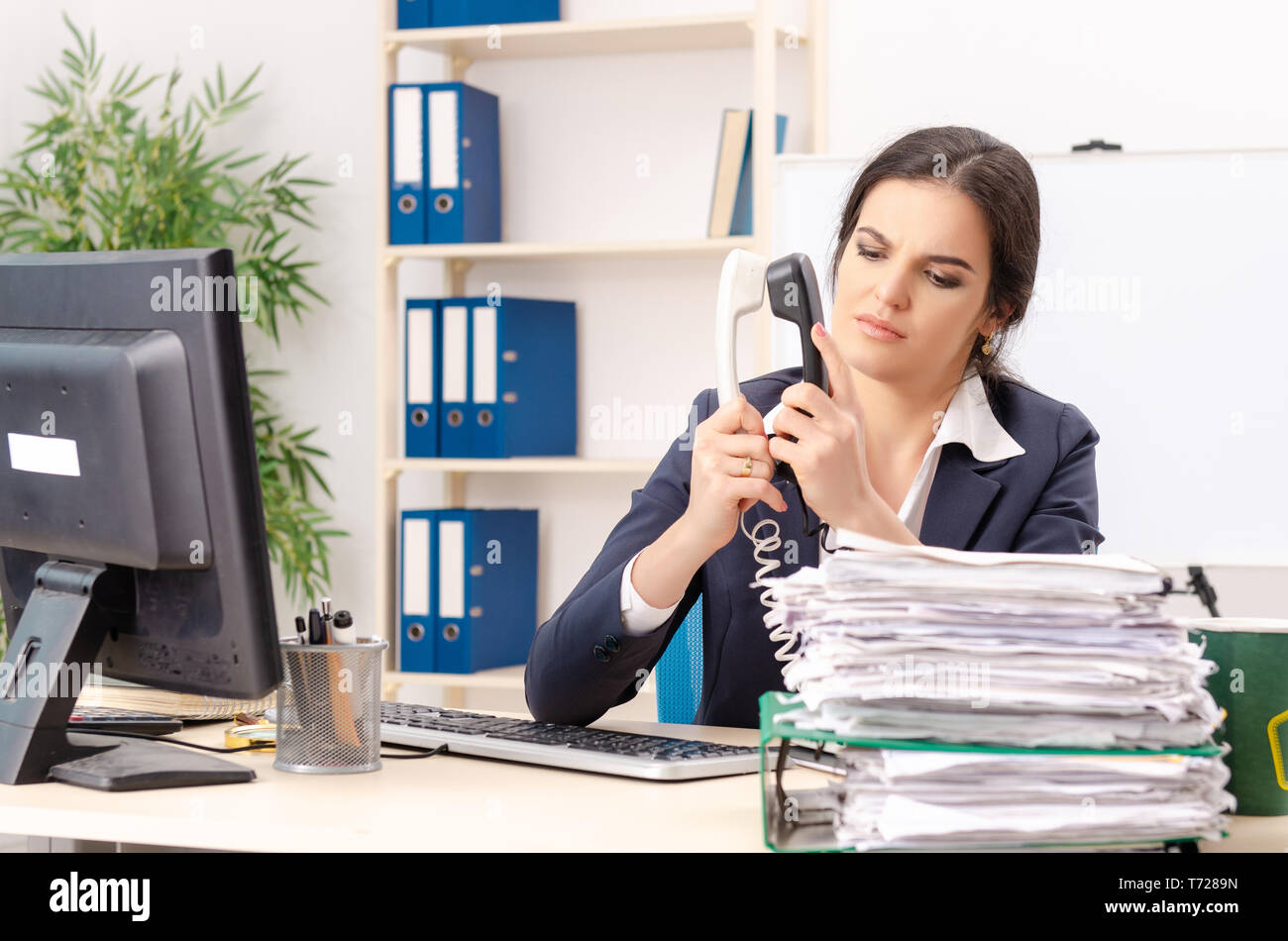 Female employee with too much work in the office Stock Photo - Alamy
