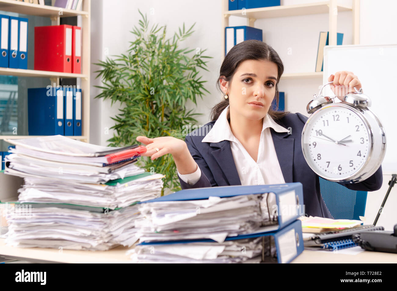 Female employee with too much work in the office Stock Photo - Alamy