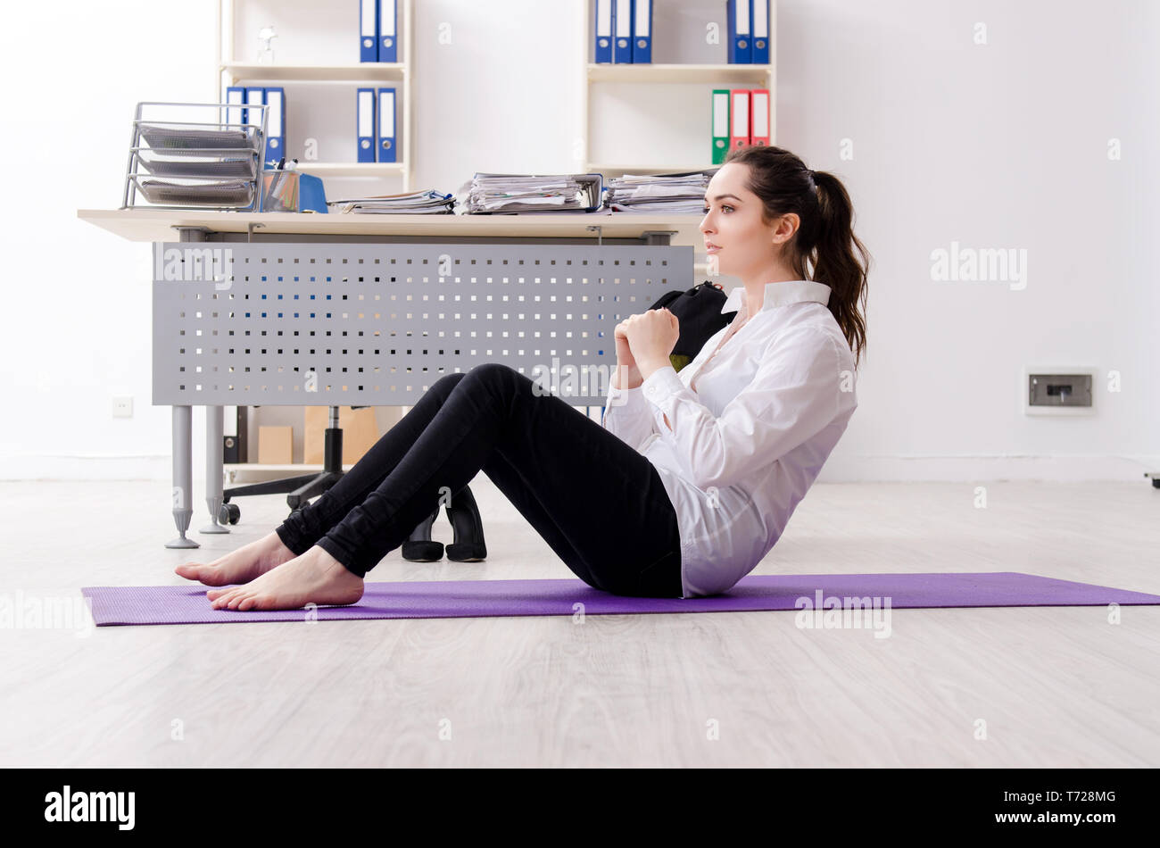 Female employee doing sport exercises in the office Stock Photo - Alamy
