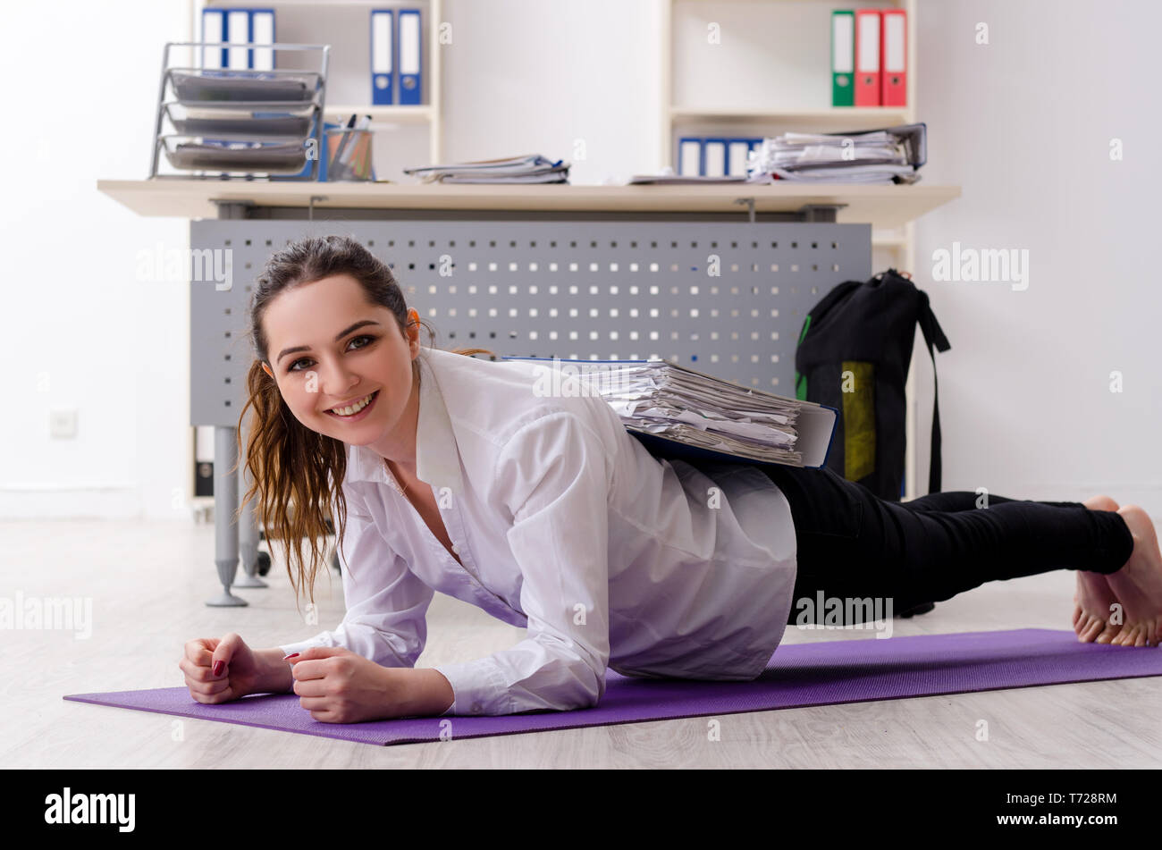 Female employee doing sport exercises in the office Stock Photo - Alamy
