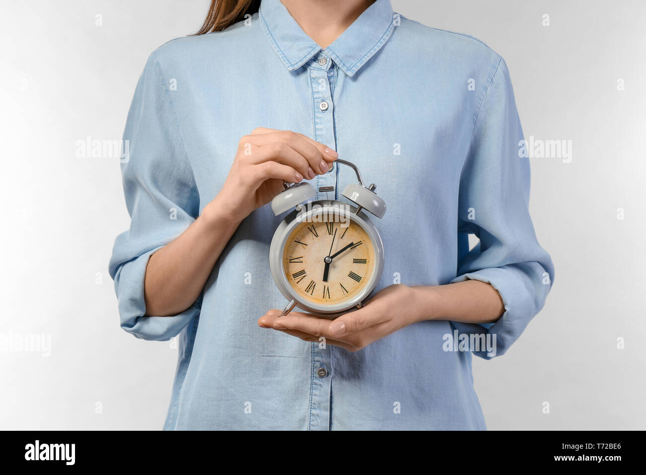 Woman with clock on light background. Time management concept Stock ...