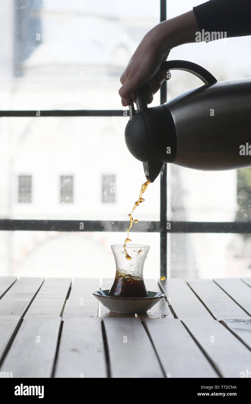 Female hand pouring tea into turkish glass Stock Photo - Alamy