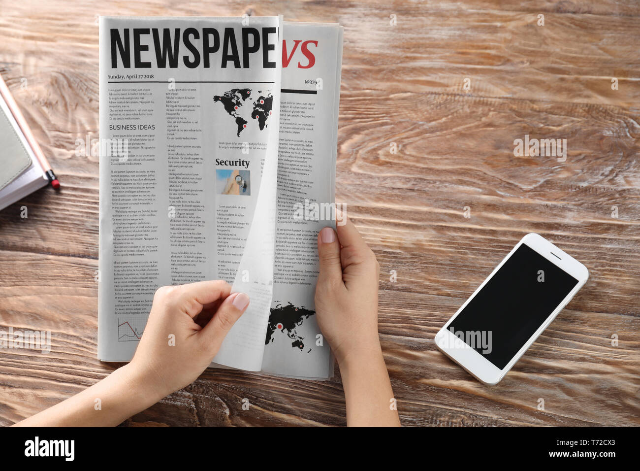 Woman reading morning newspaper at wooden table Stock Photo - Alamy