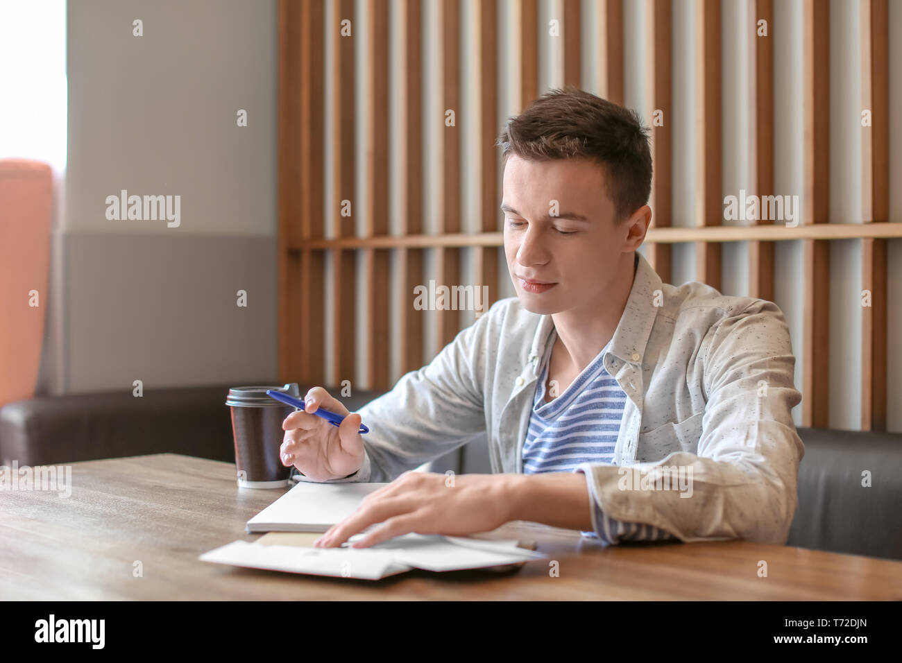 Young man writing letter at table in cafe. Mail delivery Stock Photo ...
