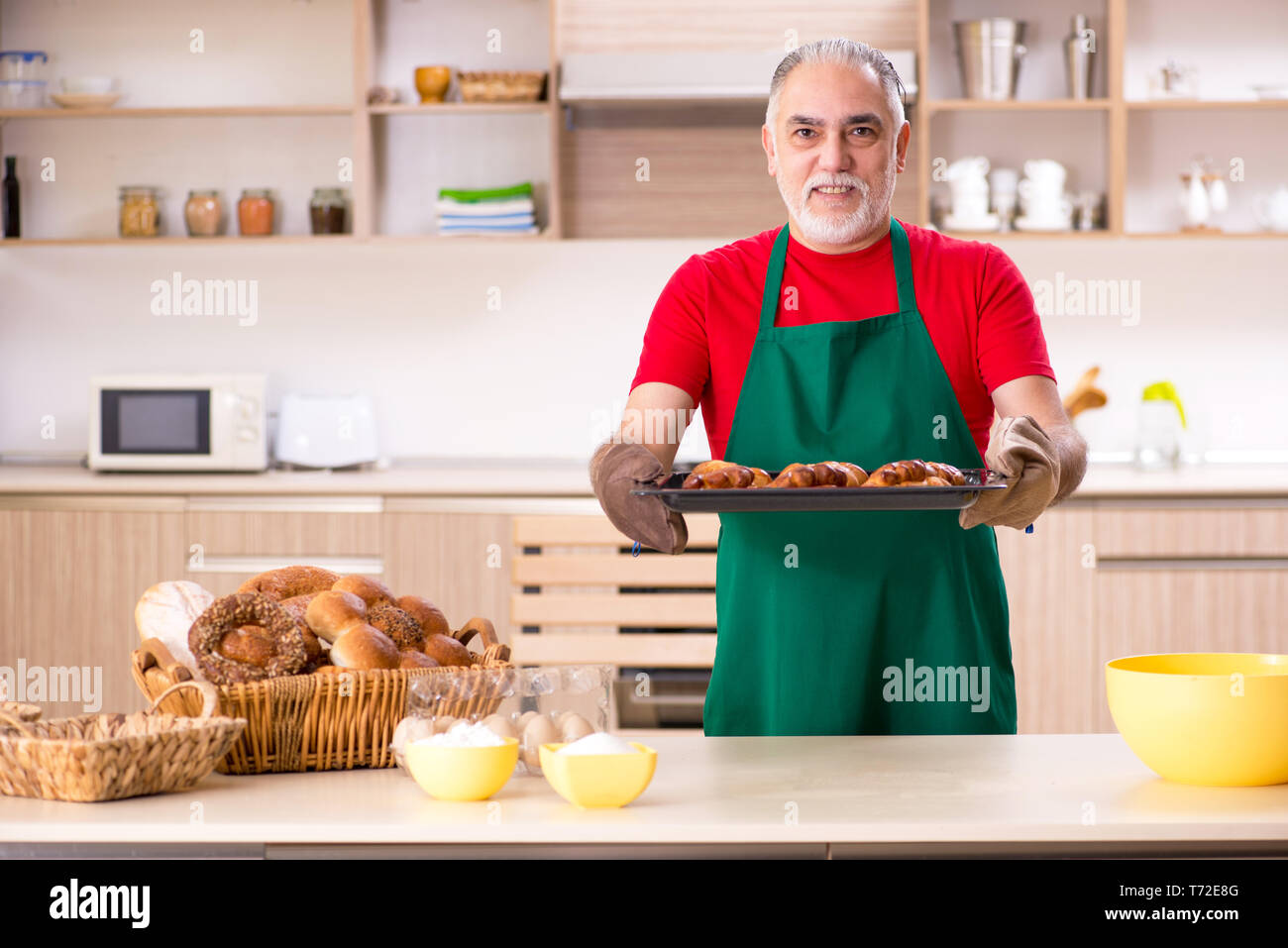 Old male baker working in the kitchen Stock Photo - Alamy