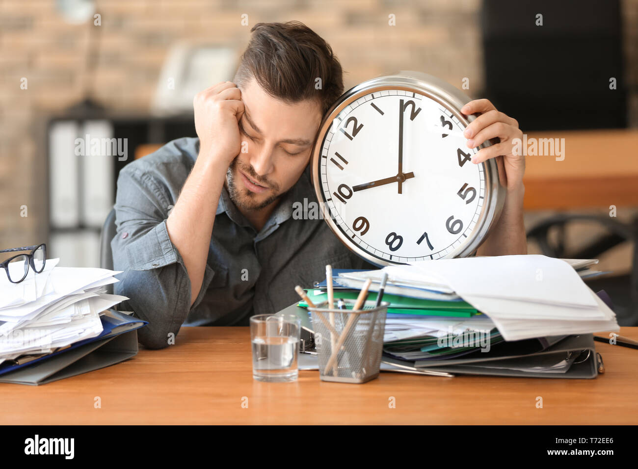 Tired businessman with clock in office. Time management concept Stock ...