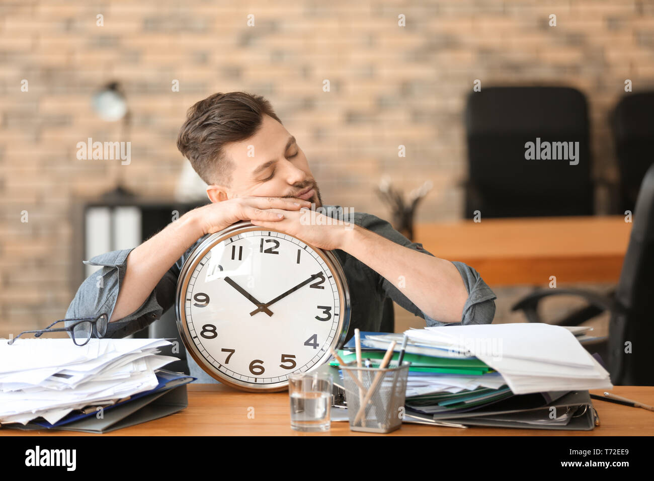 Tired businessman with clock in office. Time management concept Stock ...