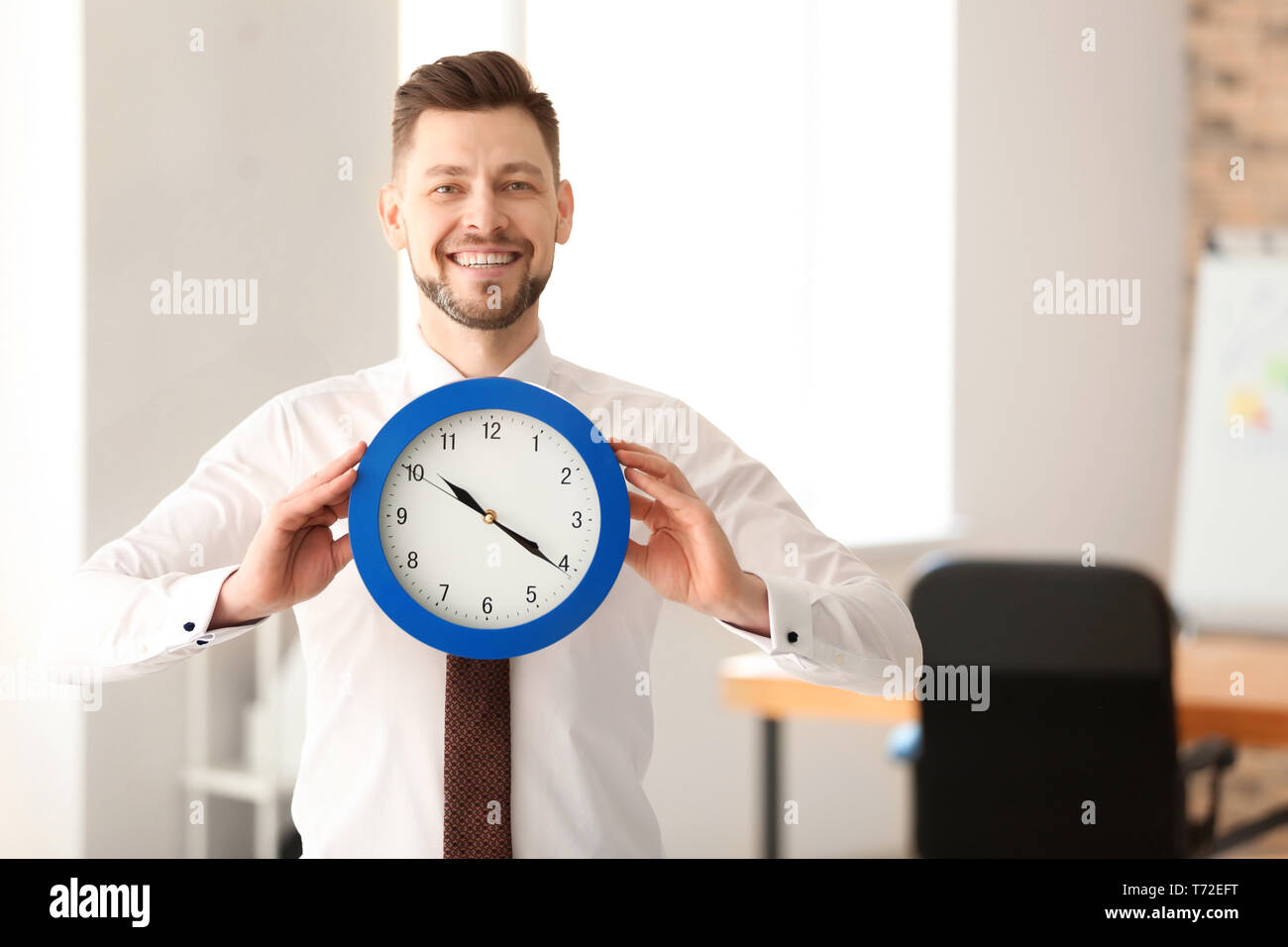 Businessman with clock in office. Time management concept Stock Photo ...