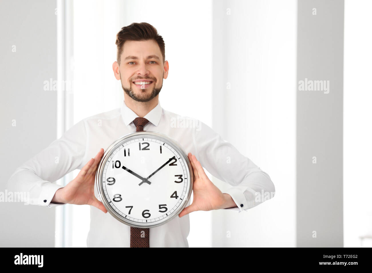 Businessman with clock in office. Time management concept Stock Photo ...